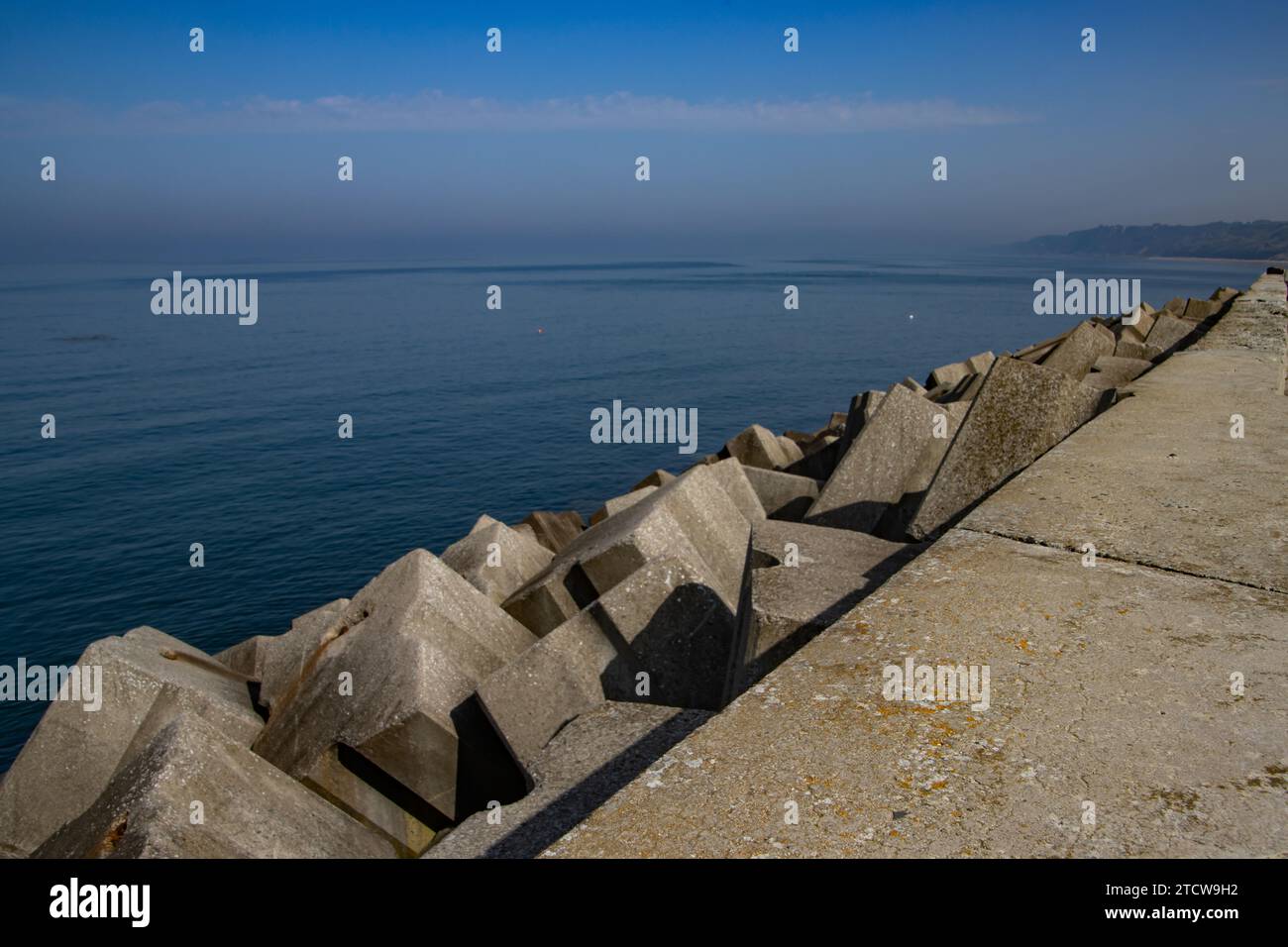 Breakwater protecting a harbor wall Stock Photo - Alamy