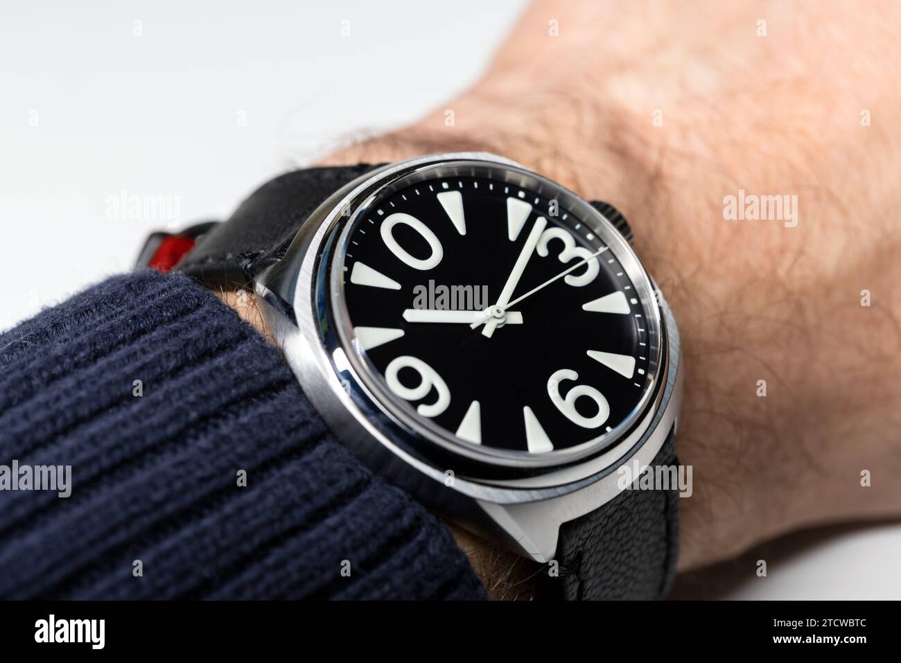 Male hand with an automatic mechanical wrist watch with bold white ...