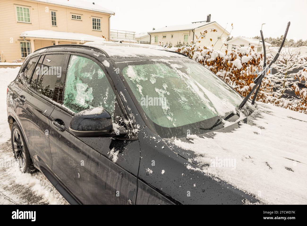 View of a car in ice and snow, with raised windshield wipers on a cold ...
