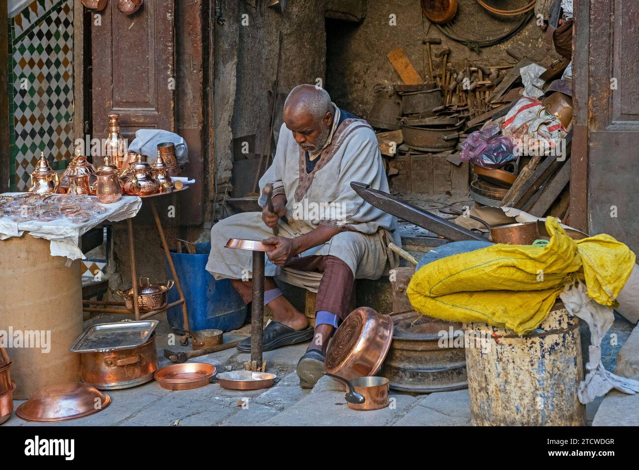 Moroccan coppersmith working in workshop on Place Seffarine, small ...