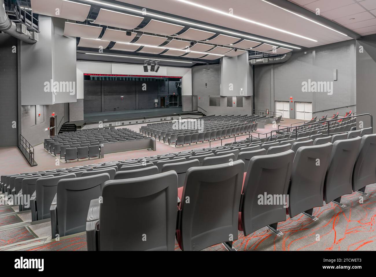 Photo of a new school theater, auditorium, with red and gray seats ...