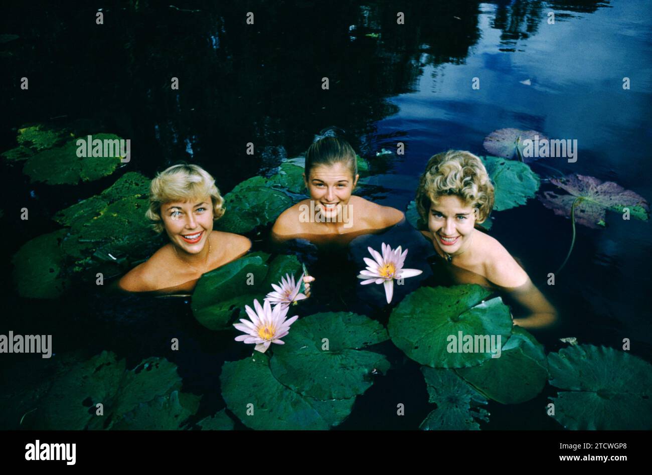 FLORIDA KEYS, FL - DECEMBER, 1958: Three women swim in a pond as they ...