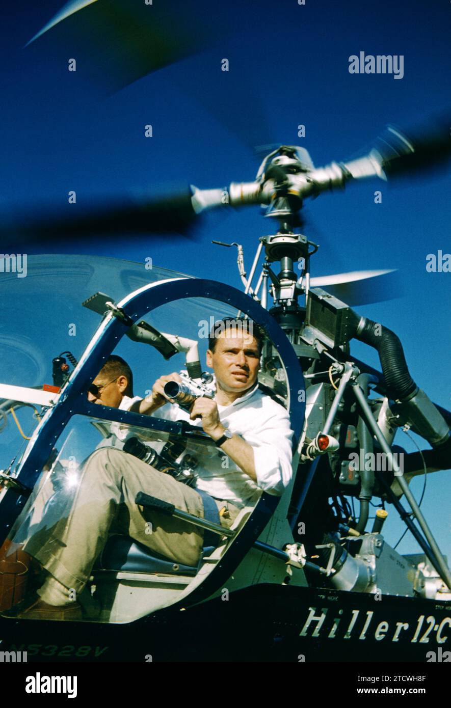 1958: American photographer Hy Peskin (1915-2005) is airlifted in a ...