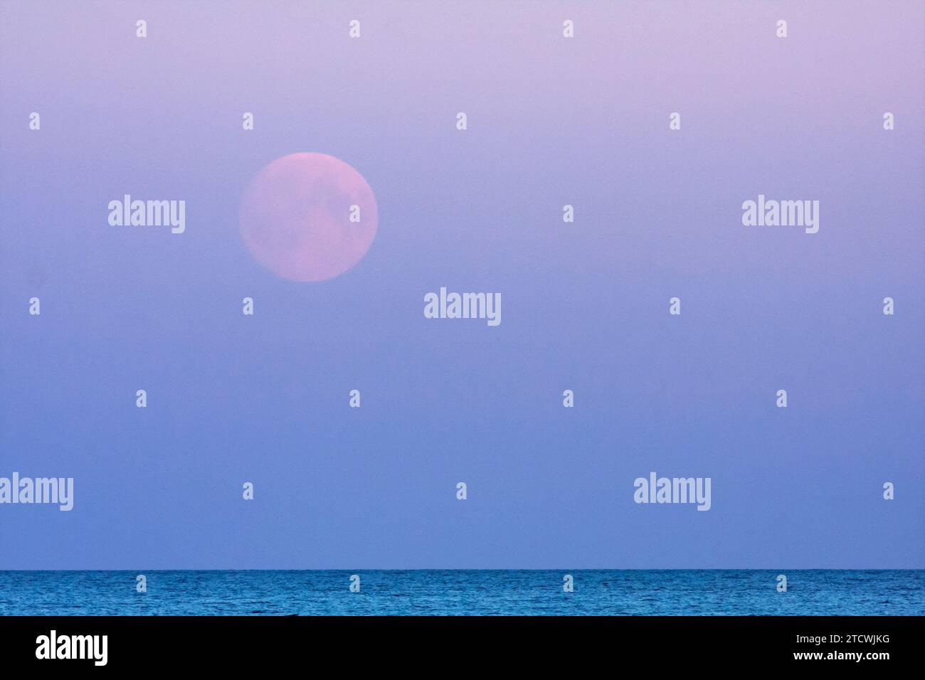 Full moon, a lunar phase, just above the sea level. Late evening up ...