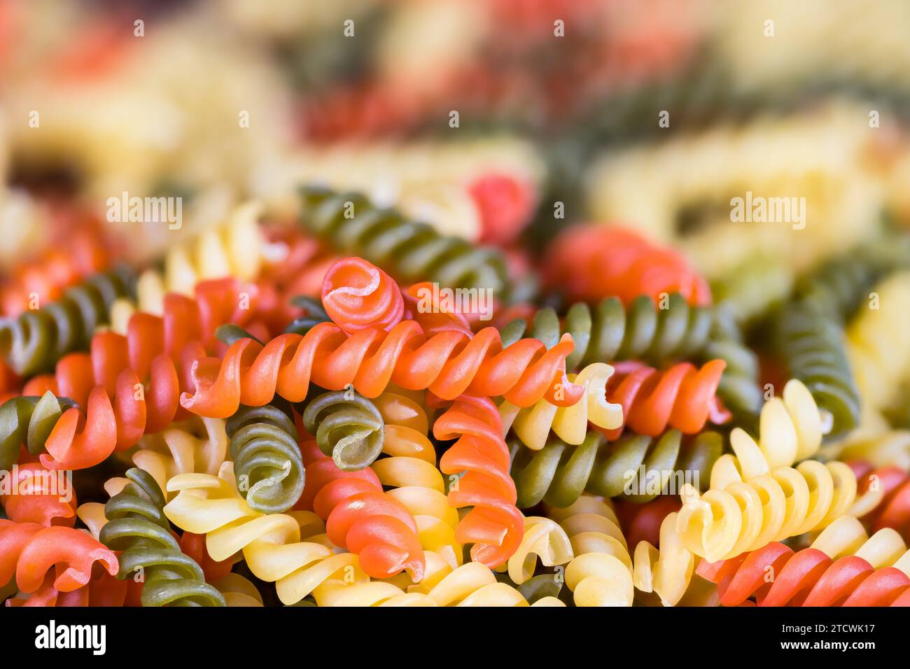 Closeup of colored spiral twisted fusilli pasta on pile with blurred ...