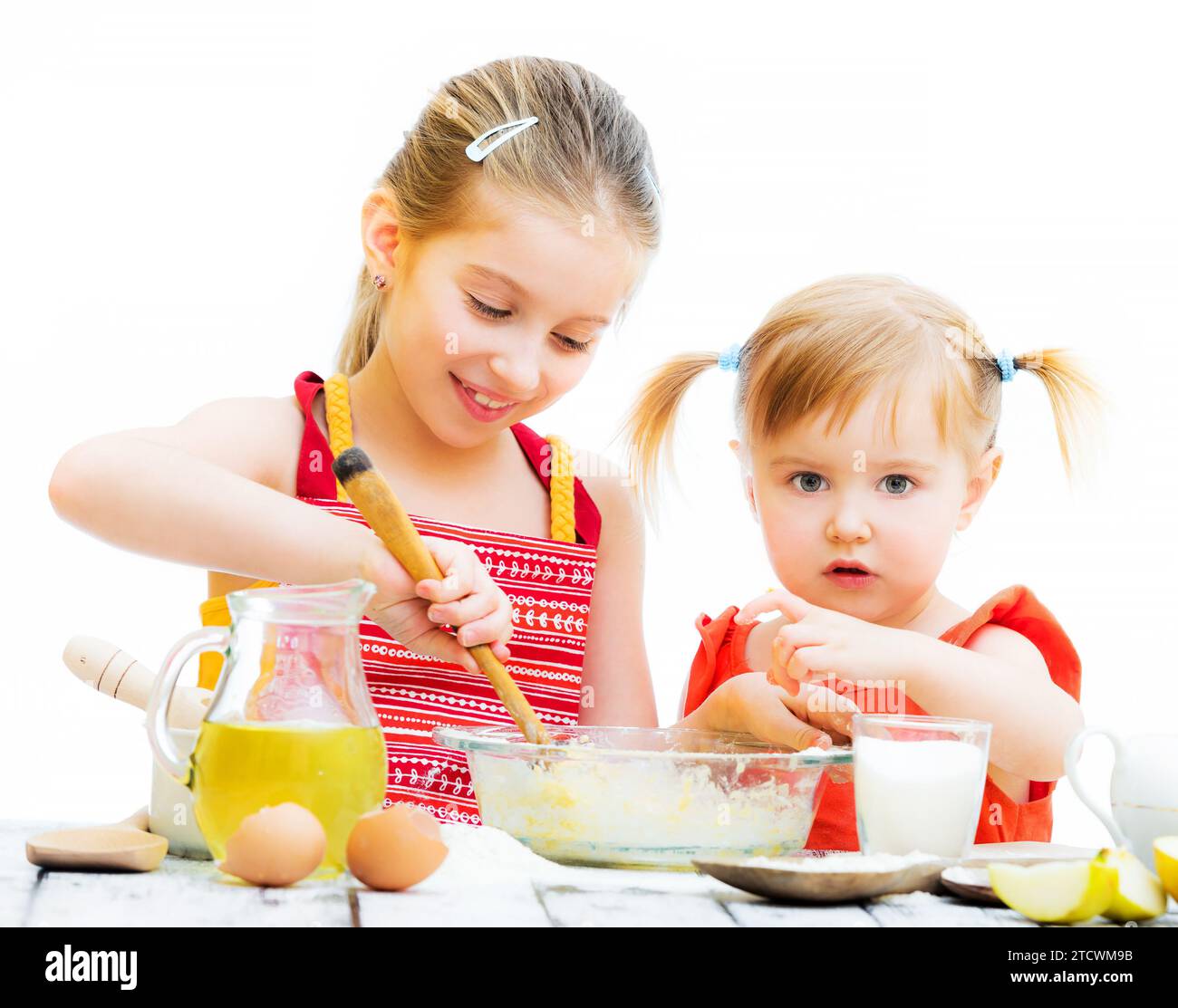 two little sisters baking isolated on a white background Stock Photo ...