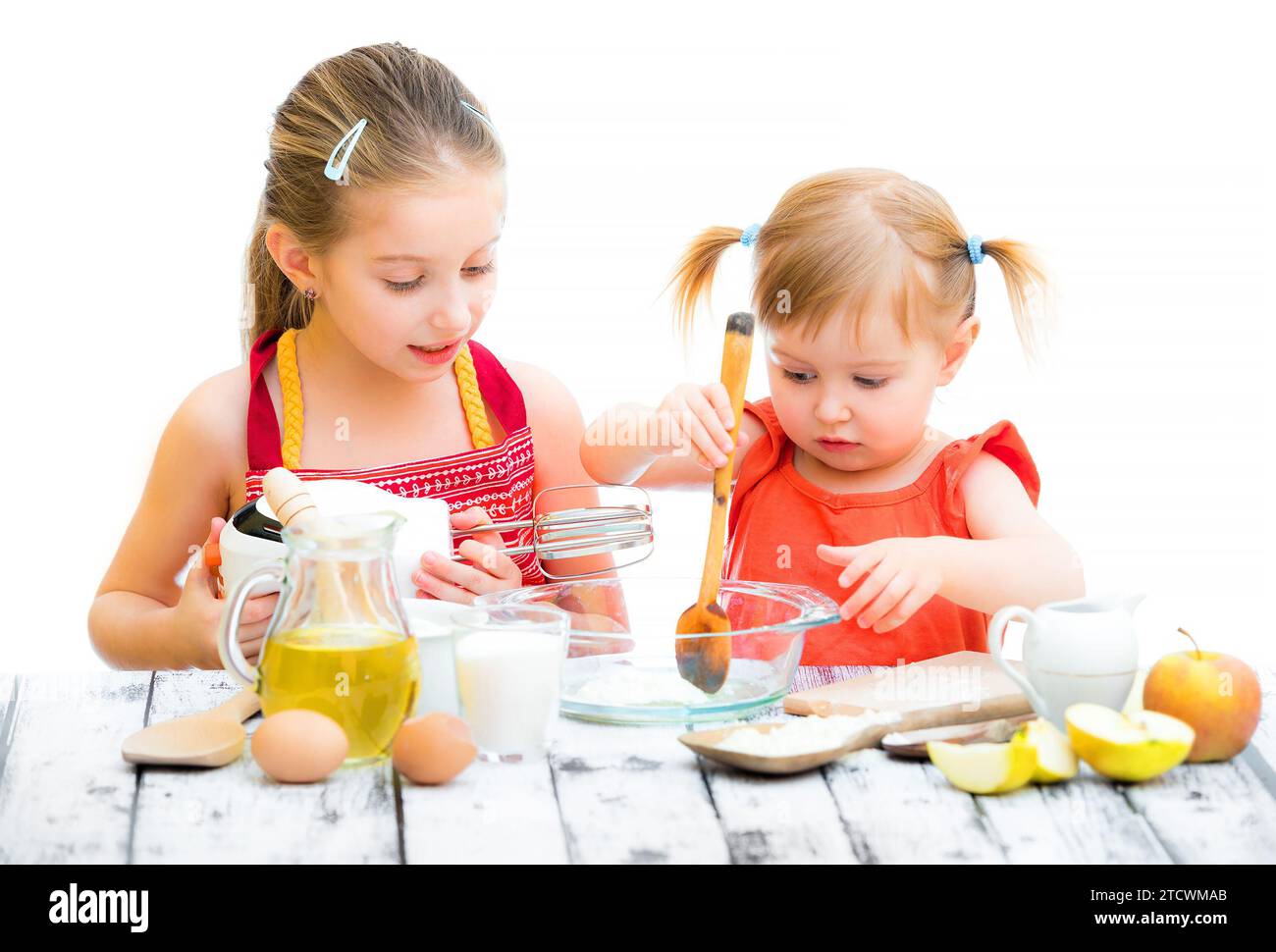 two little sisters cooking isolated on a white background Stock Photo ...