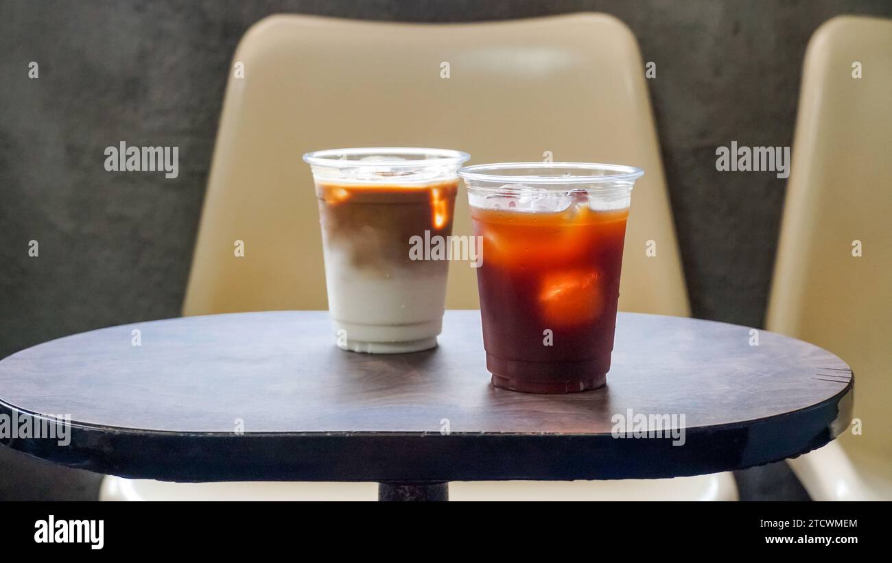 Ice americano and cafe latte on the table. Two plastic take away cup of ...