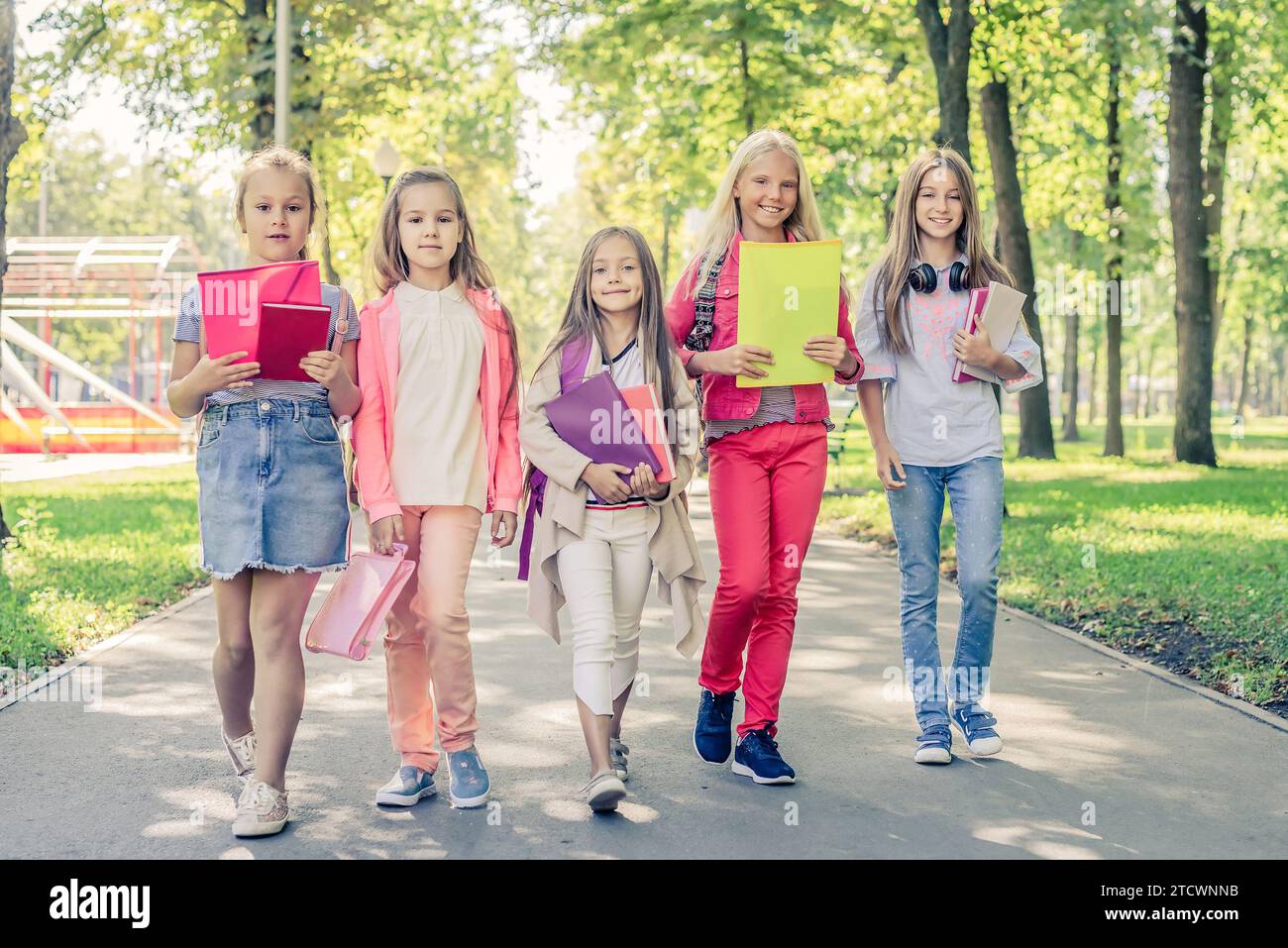 Little girls walking in the park with school books and notes Stock ...