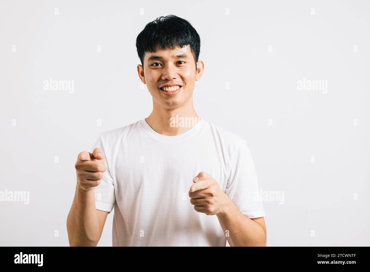 Happy Asian man playfully points two fingers at the camera with a ...