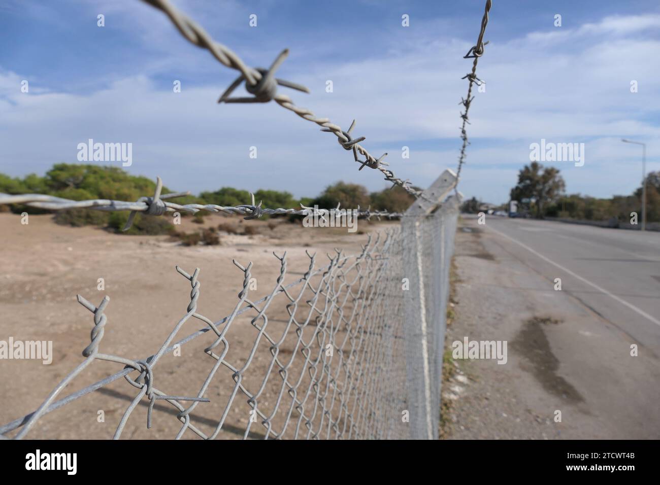 Barbed wire fence on the road. The concept of restriction of movement ...