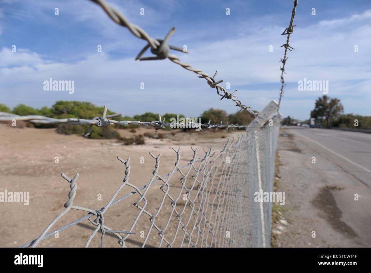 Barbed wire fence on the road. The concept of restriction of movement ...