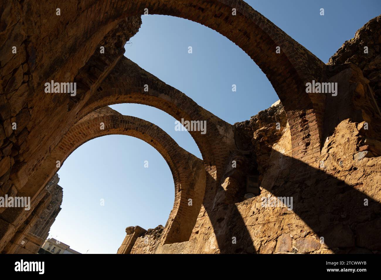 Ancient stone arches against a clear blue sky, historical ruins with ...