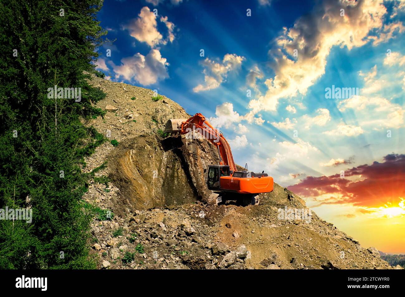 Excavator at a construction site on the side of a hill against a cloudy ...