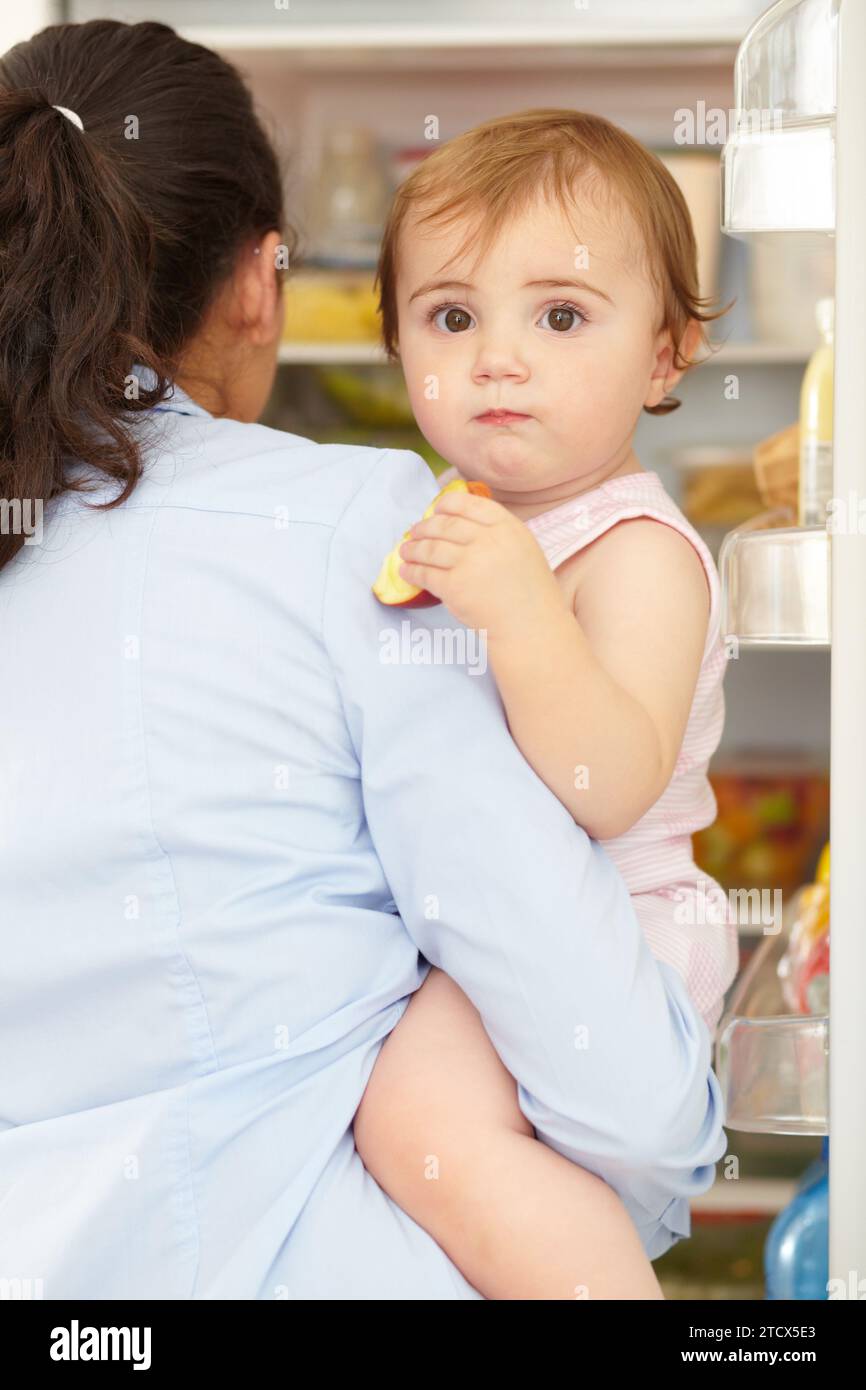 Portrait, woman and fruit of toddler in kitchen, open fridge and food ...