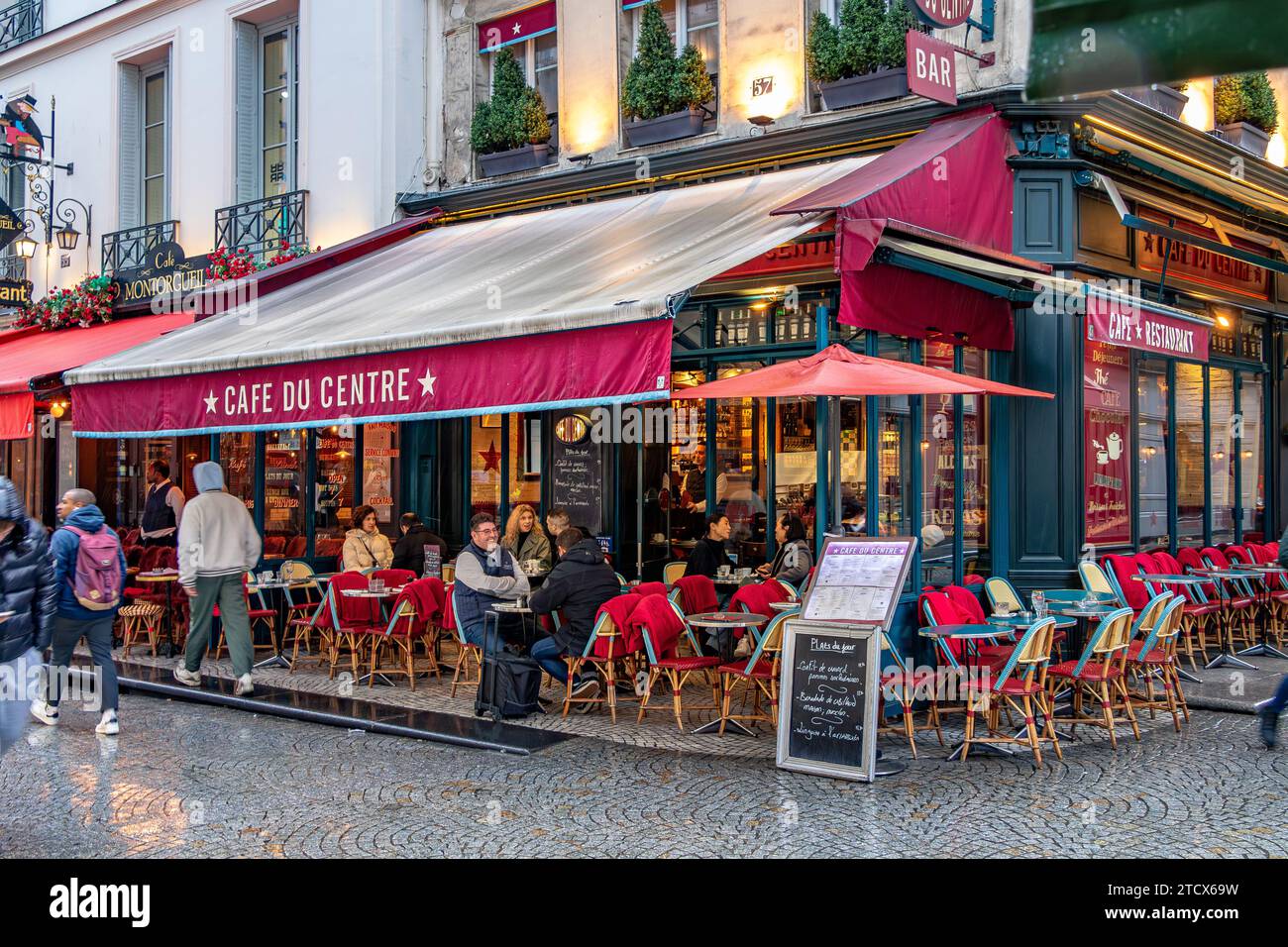 People sitting down on the outdoor terrace at Café du centre, a French ...