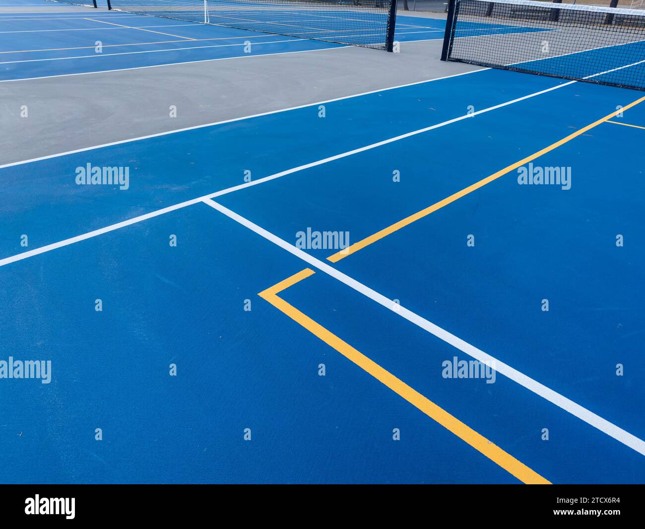 Close up photo of a outdoor blue tennis court with white lines combined ...