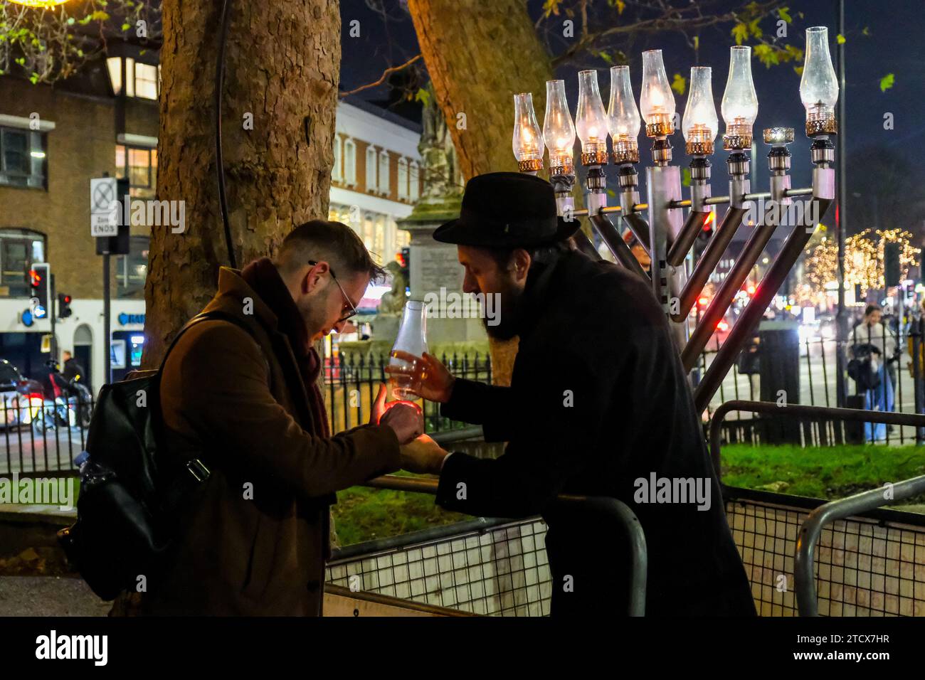 London, UK. 14th December, 2023. Islington's Rabbi Mendy Korer lights a ...