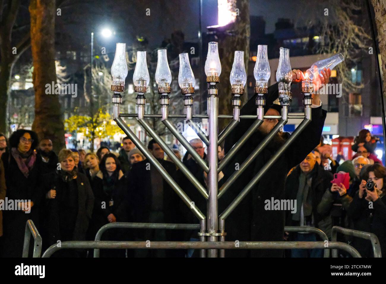 London, UK. 14th December, 2023. Islington's Rabbi Mendy Korer lights a ...