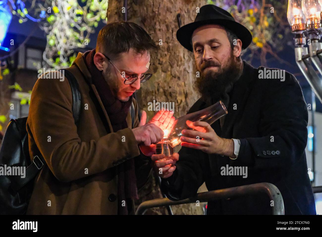 London, UK. 14th December, 2023. Islington's Rabbi Mendy Korer lights a ...
