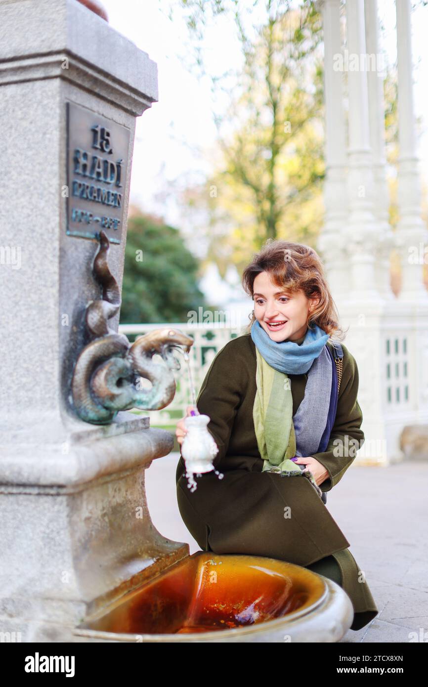 girl drink water from the Snake Spring mineral water in resort town ...