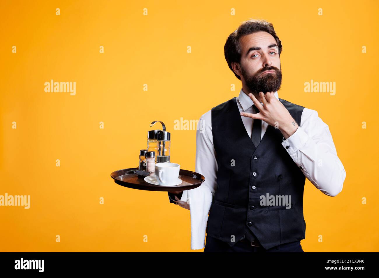 Stylish waiter posing with food tray against yellow background ...