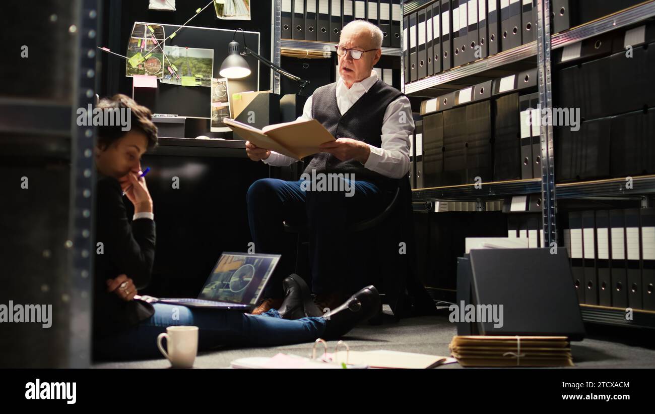 Law officers review case files in incident room, reading confidential ...