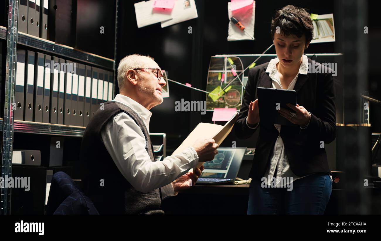 Detectives team working in incident room to create profile of the ...