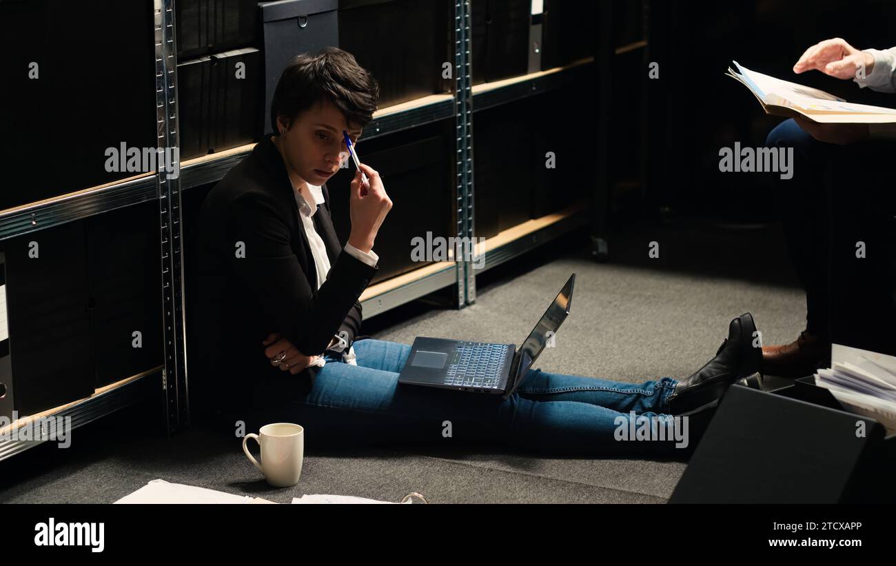 Partners analyze case files with laptop, thinking about ways to uncover ...