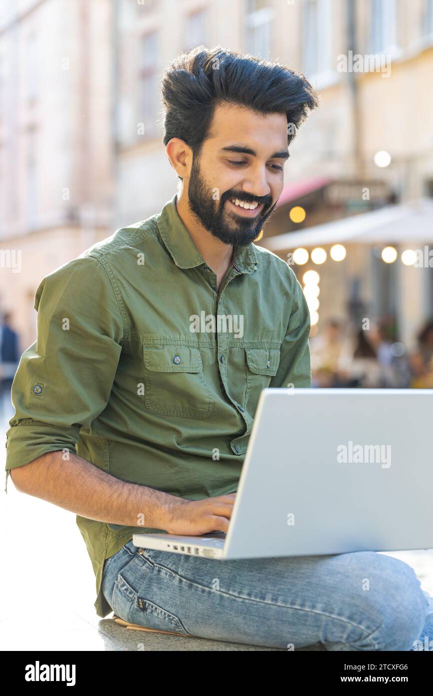 Indian man freelancer working online distant job with laptop sits in ...