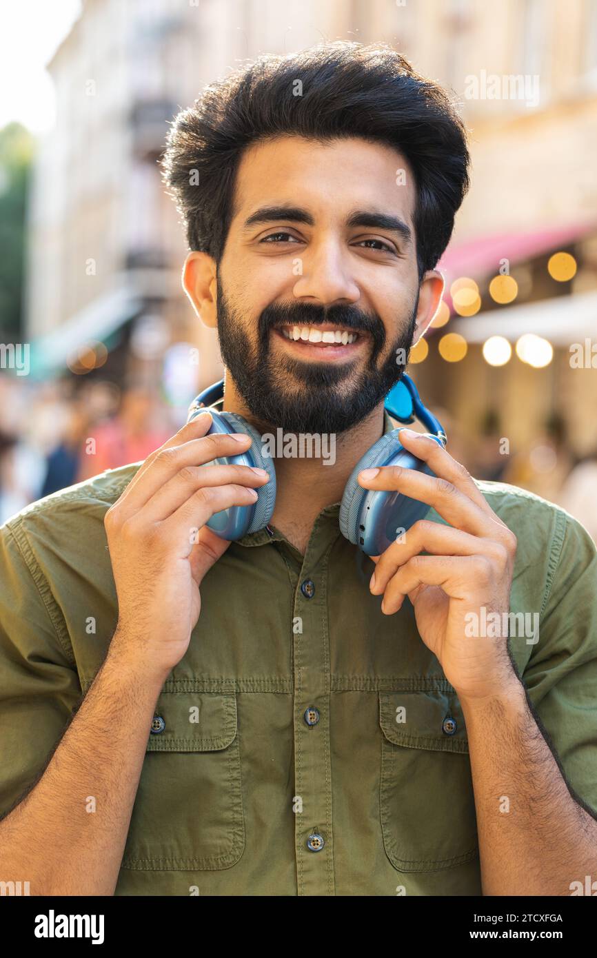 Joyful relaxed overjoyed indian man choosing, listening favorite ...