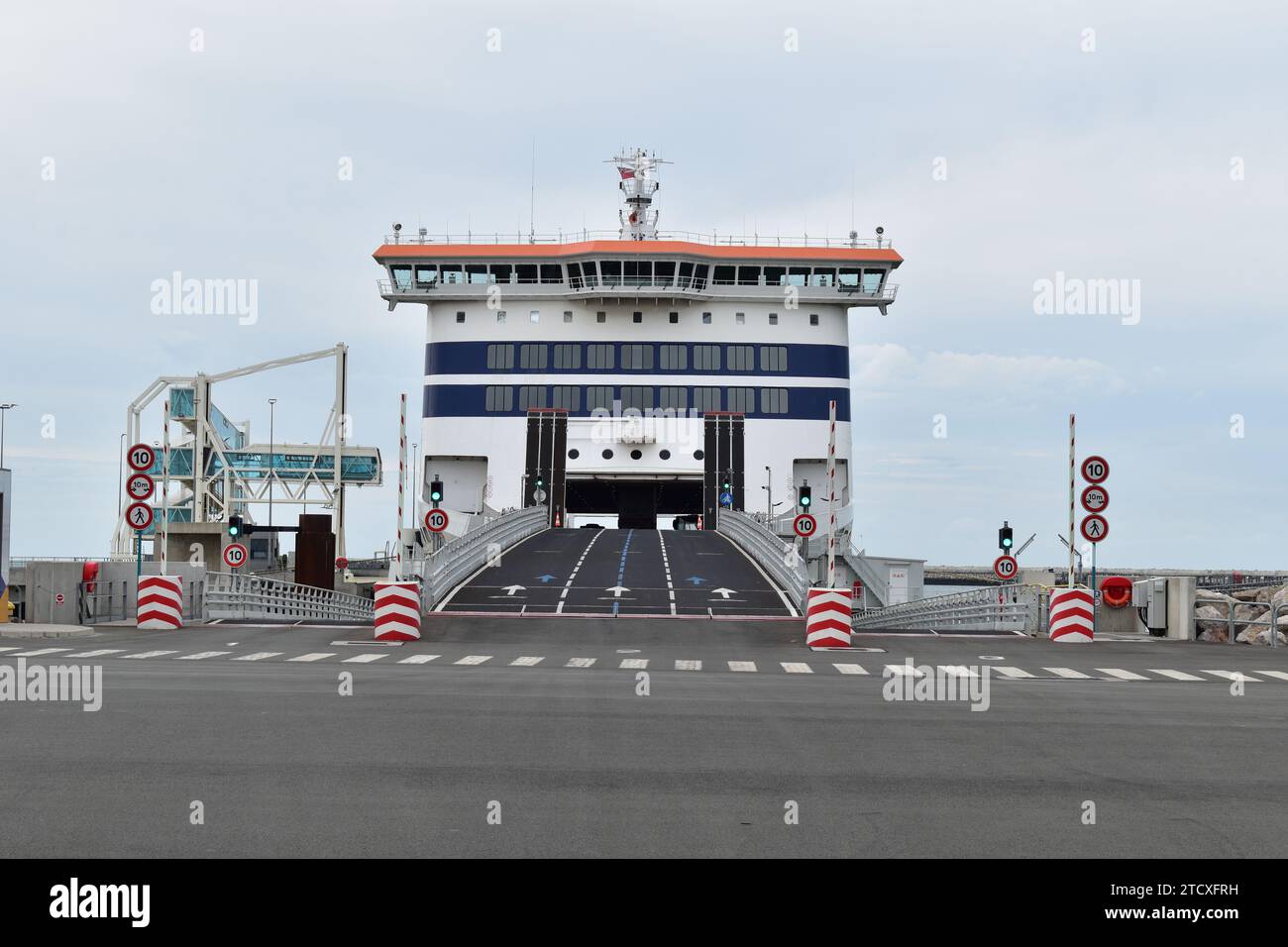 Road with three lanes that leads to the vehicle entrance of the ferry ...