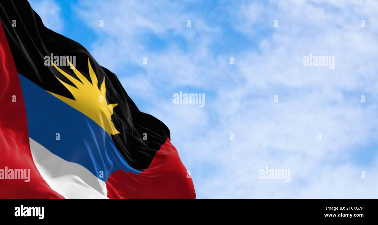 Antigua and Barbuda national flag waving on a clear day. Red field with ...