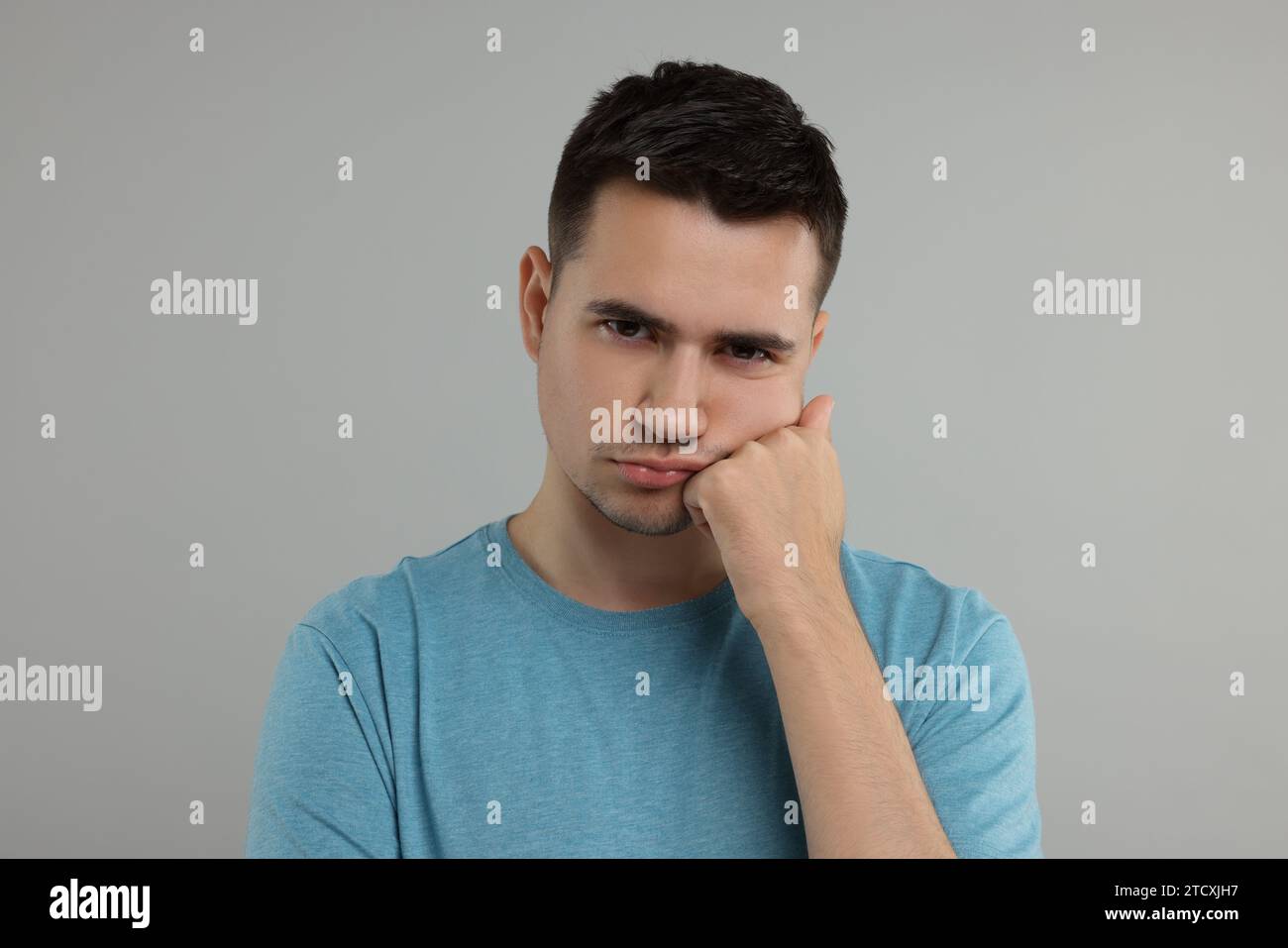 Portrait of resentful man on grey background Stock Photo - Alamy