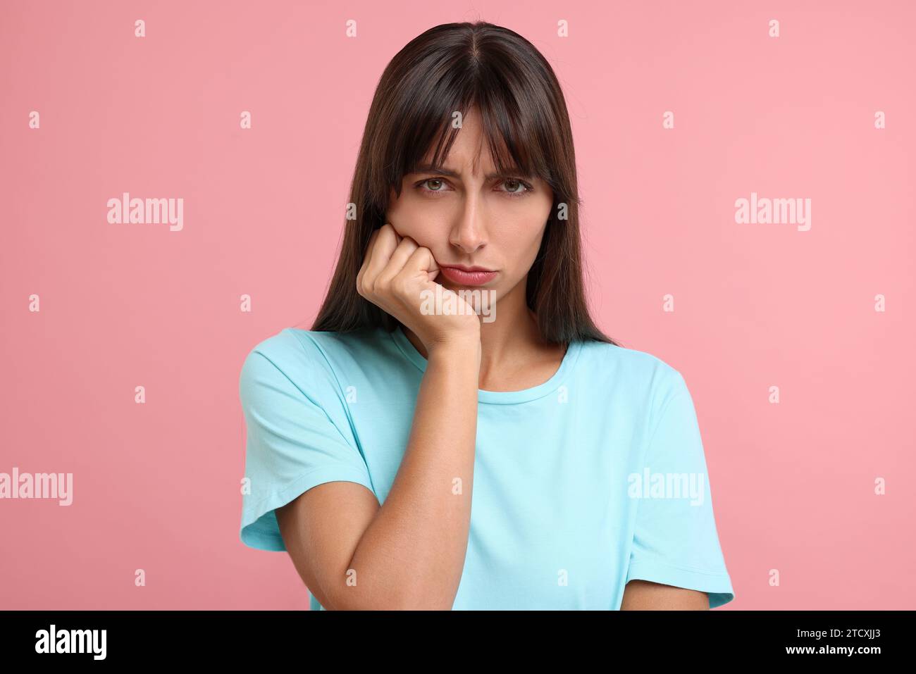 Portrait of resentful woman on pink background Stock Photo - Alamy