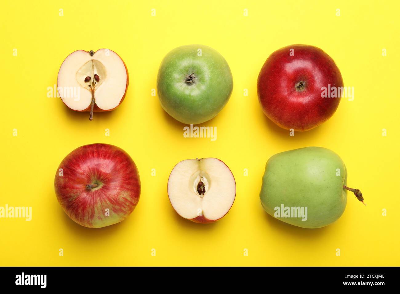 Whole and cut colorful apples on yellow background, flat lay Stock ...