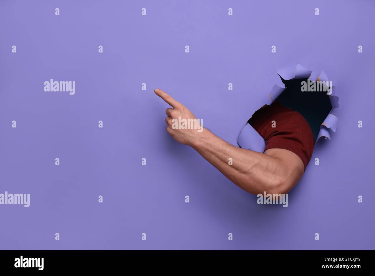 Special promotion. Man pointing at something through hole in purple ...