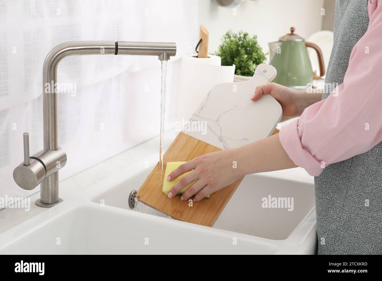Woman washing cutting board at sink in kitchen, closeup Stock Photo - Alamy