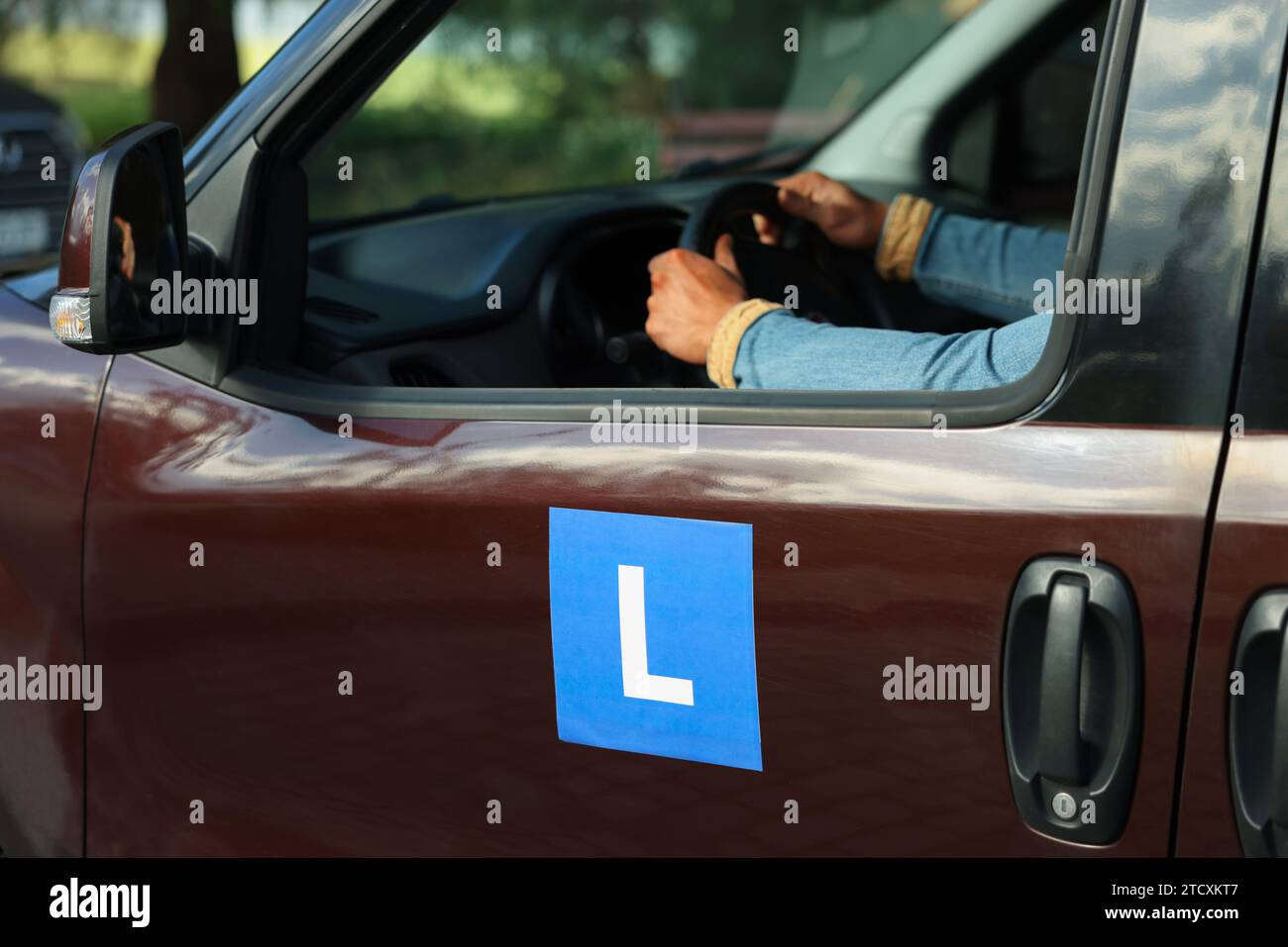Learner driver driving car with L-plate, view from outside. Driving ...