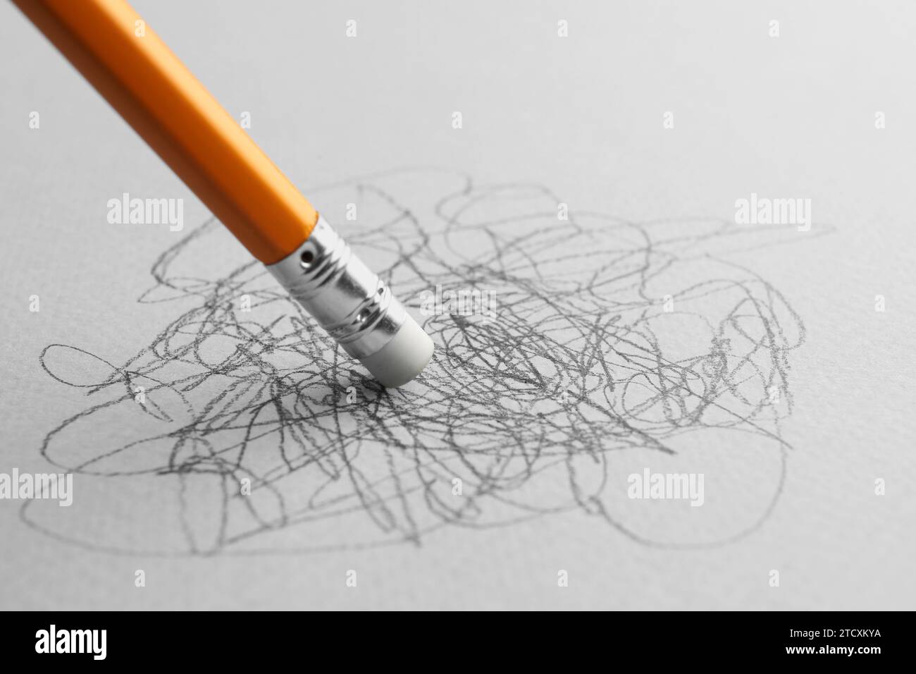Erasing scribbles with graphite pencil on white background, closeup ...