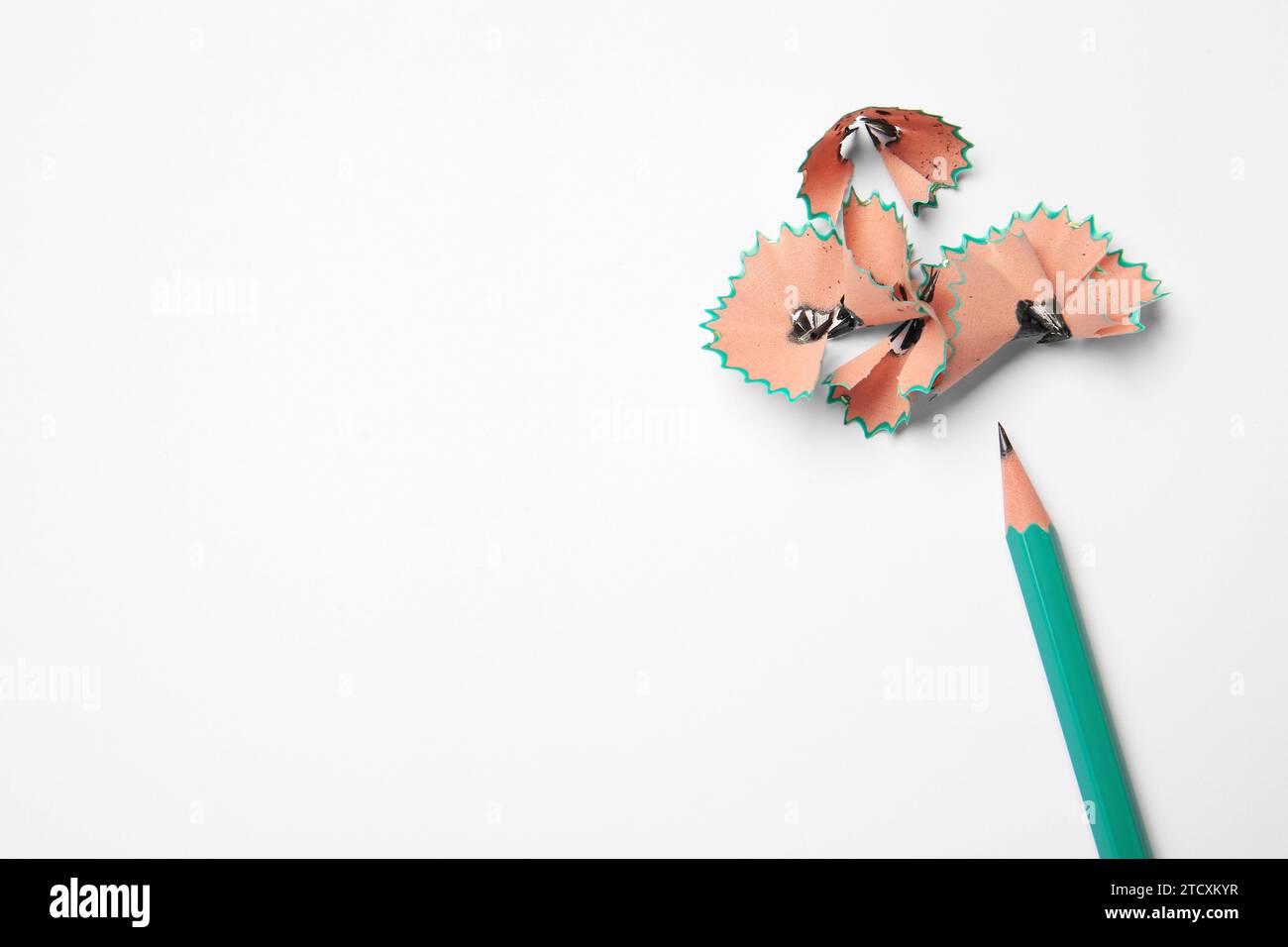 Sharp graphite pencil and shavings on white background, top view. Space ...