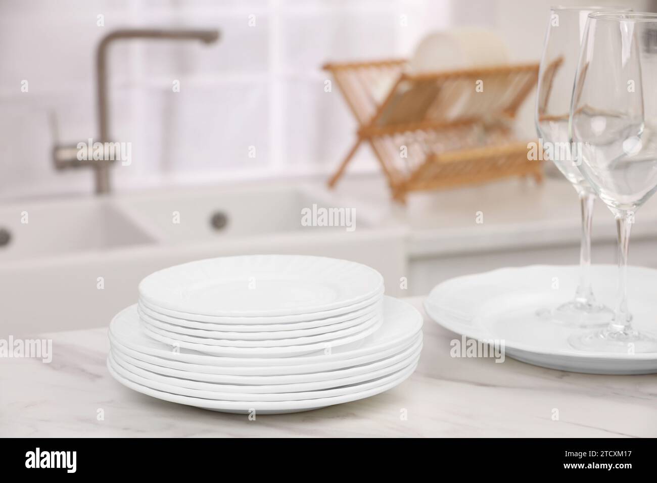 Clean dishes on light table in kitchen Stock Photo - Alamy
