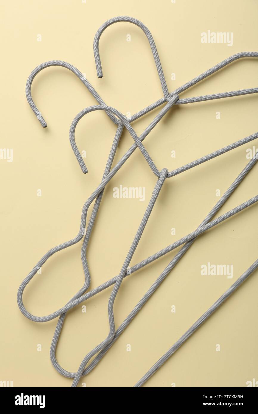 Hangers on pale yellow background, flat lay Stock Photo - Alamy