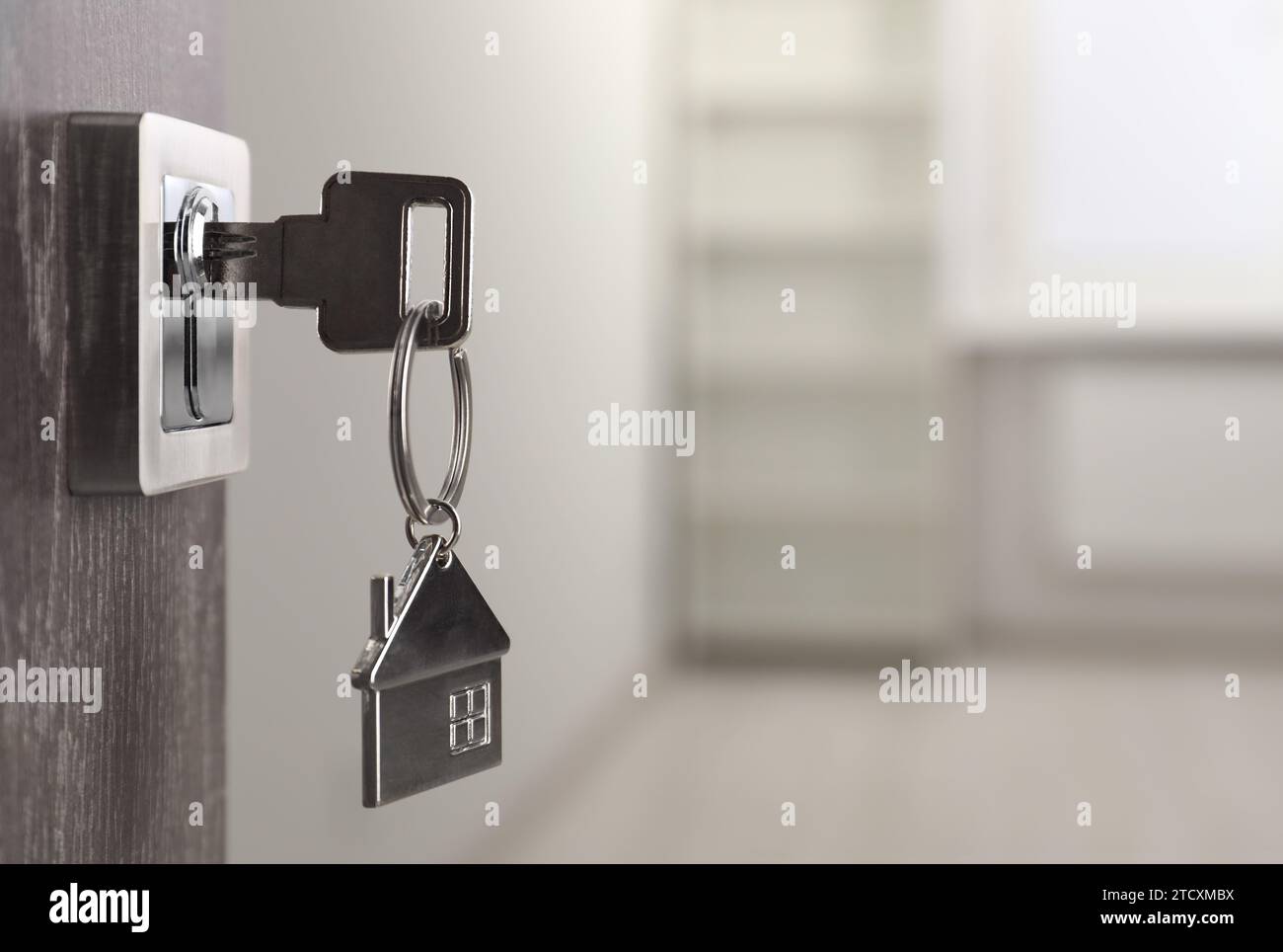 Mortgage and real estate. Open door with key and house shaped keychain ...