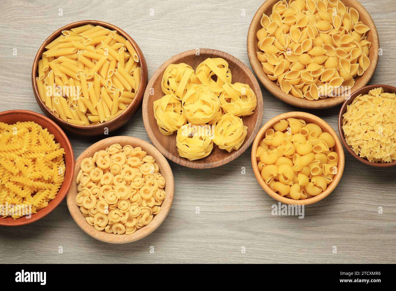 Different types of pasta on light grey wooden table, flat lay Stock ...