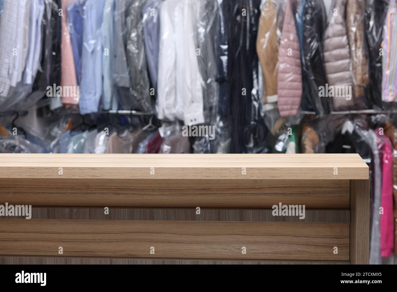 Dry-cleaning service. Hangers with different clothes in plastic bags on ...