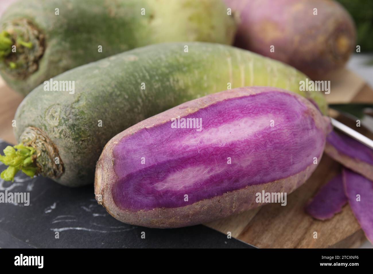 Purple and green daikon radishes on board, closeup Stock Photo - Alamy