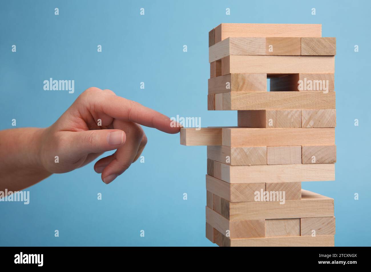 Woman playing Jenga on light blue background, closeup Stock Photo - Alamy