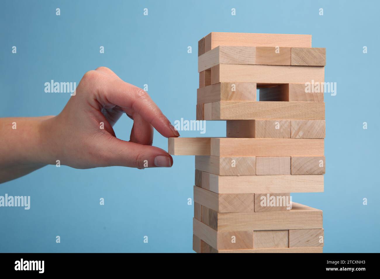 Woman playing Jenga on light blue background, closeup Stock Photo - Alamy