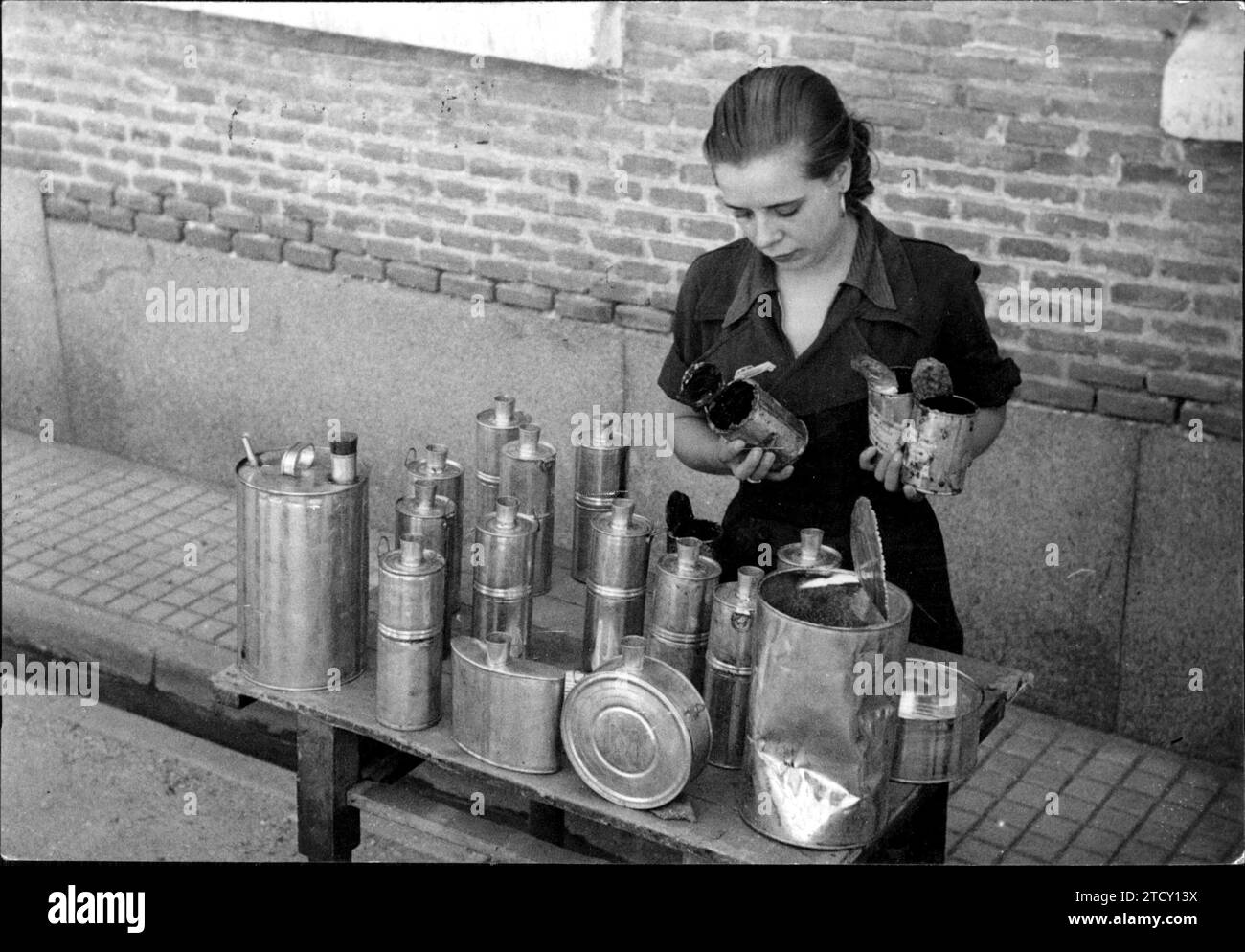 11/30/1938. Woman Comparing the Dented and Dirty Canisters with the ...